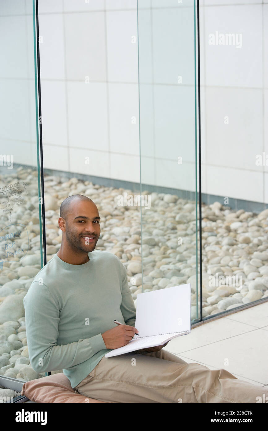African man writing in notepad Stock Photo - Alamy