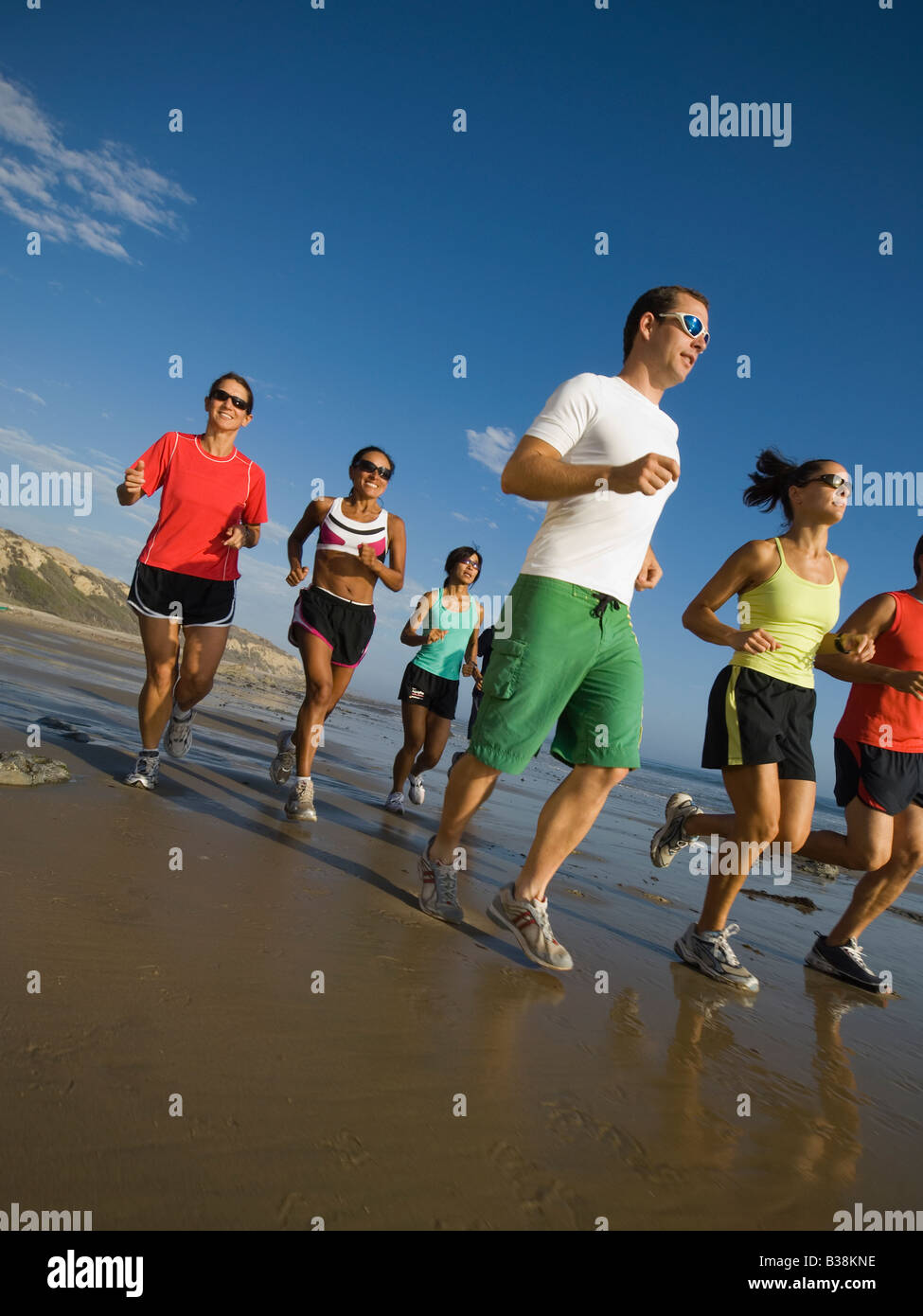 Multi-ethnic runners racing at beach Stock Photo - Alamy