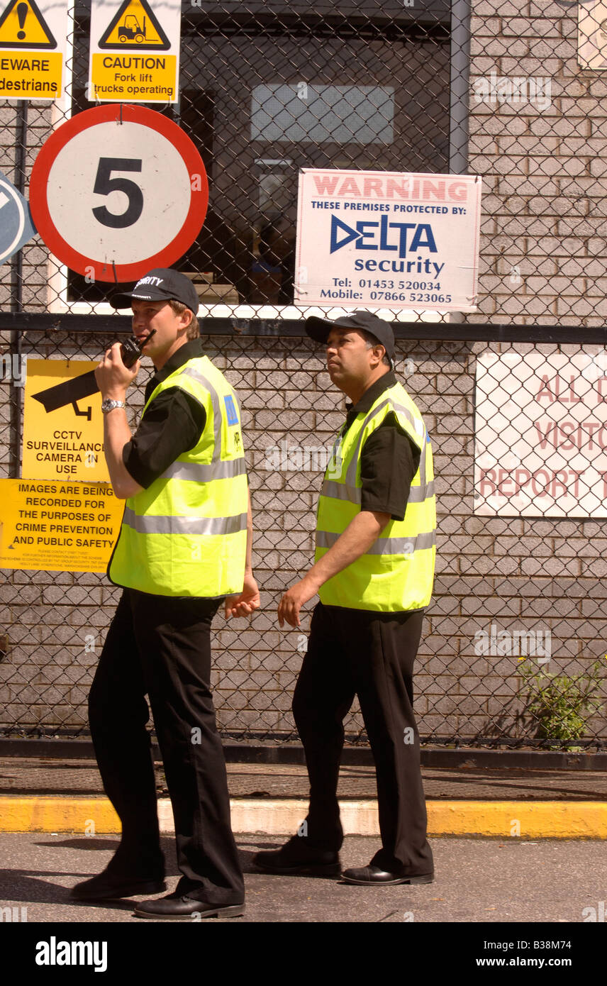 TWO SECURITY GUARDS PATROL THE PERIMETER OF SECURE PREMISES UK Stock ...
