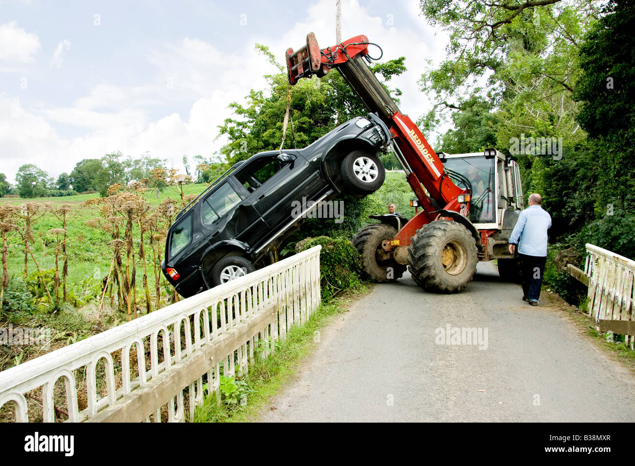 a crashed 4x4 SUV gets pulled out from by a tractor Stock Photo - Alamy