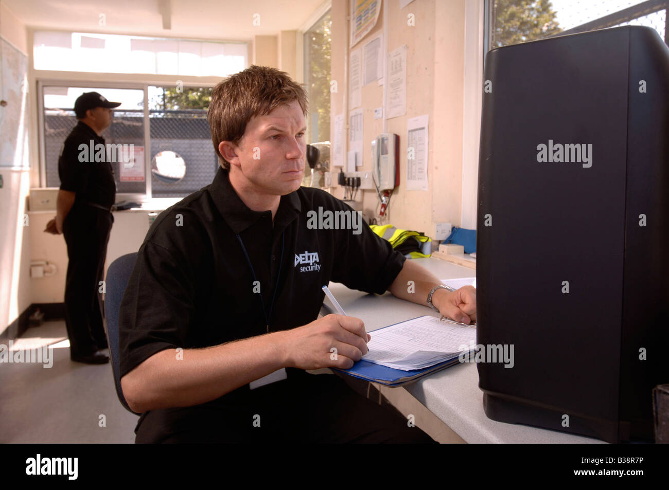 A SECURITY GUARD CHECKS CCTV IMAGES AT A CHECKPOINT UK Stock Photo - Alamy