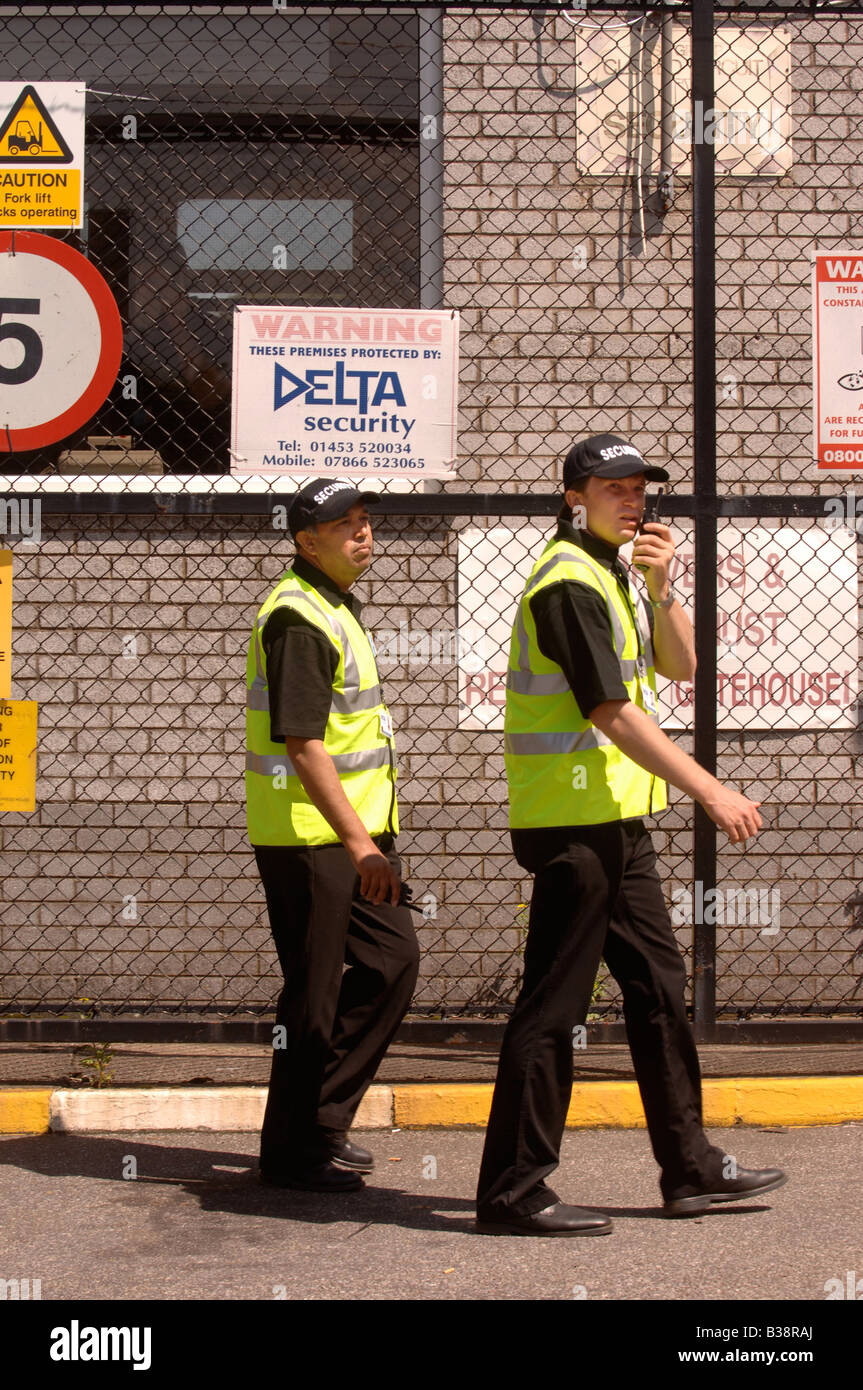 TWO SECURITY GUARDS PATROL THE PERIMETER OF SECURE PREMISES UK Stock ...
