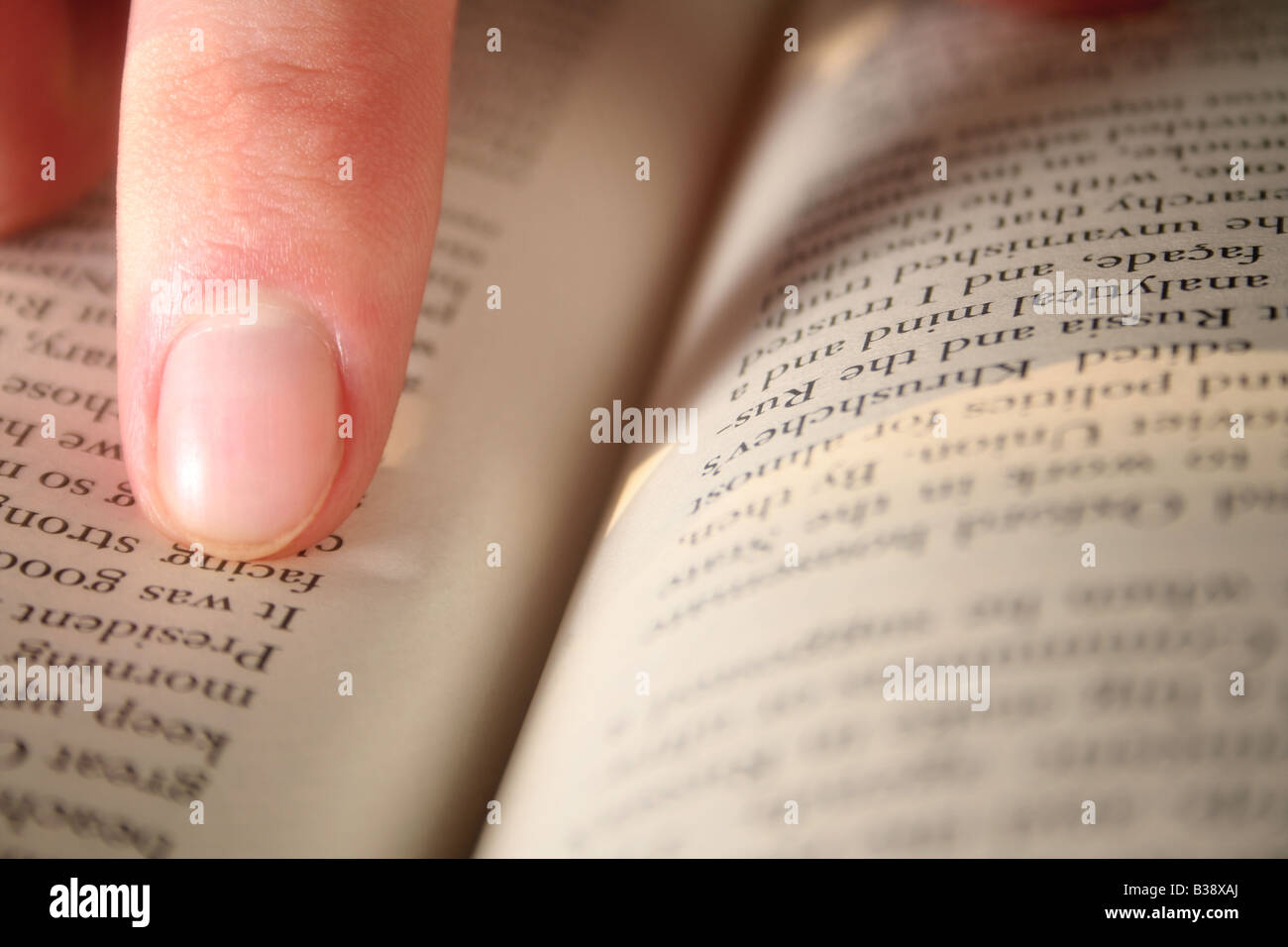 A finger pointing to a passage in a book Stock Photo - Alamy