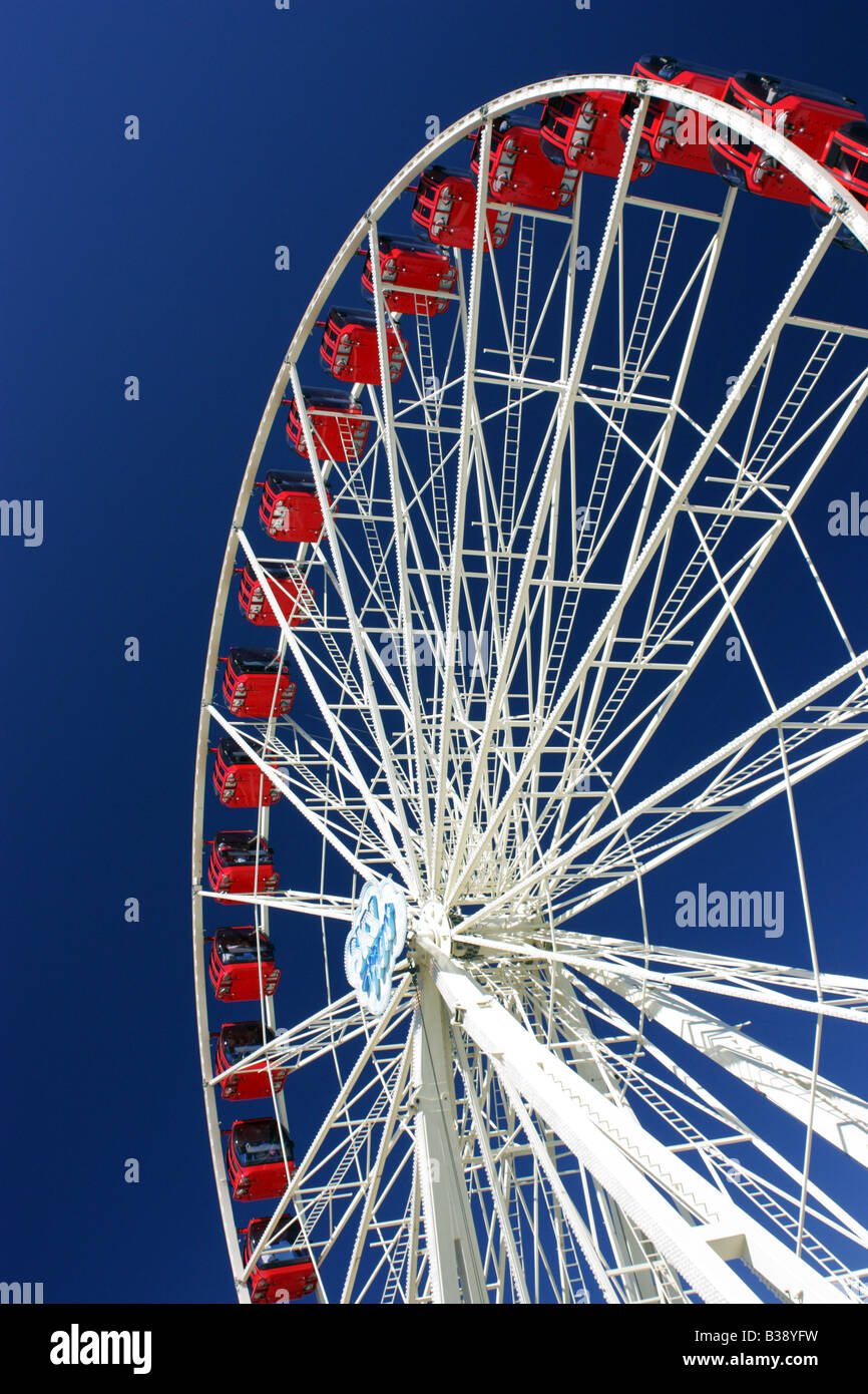 WHITE FERRIS WHEEL WITH RED CARRIAGES AGAINST BLUE SKY BACKGROUND ...