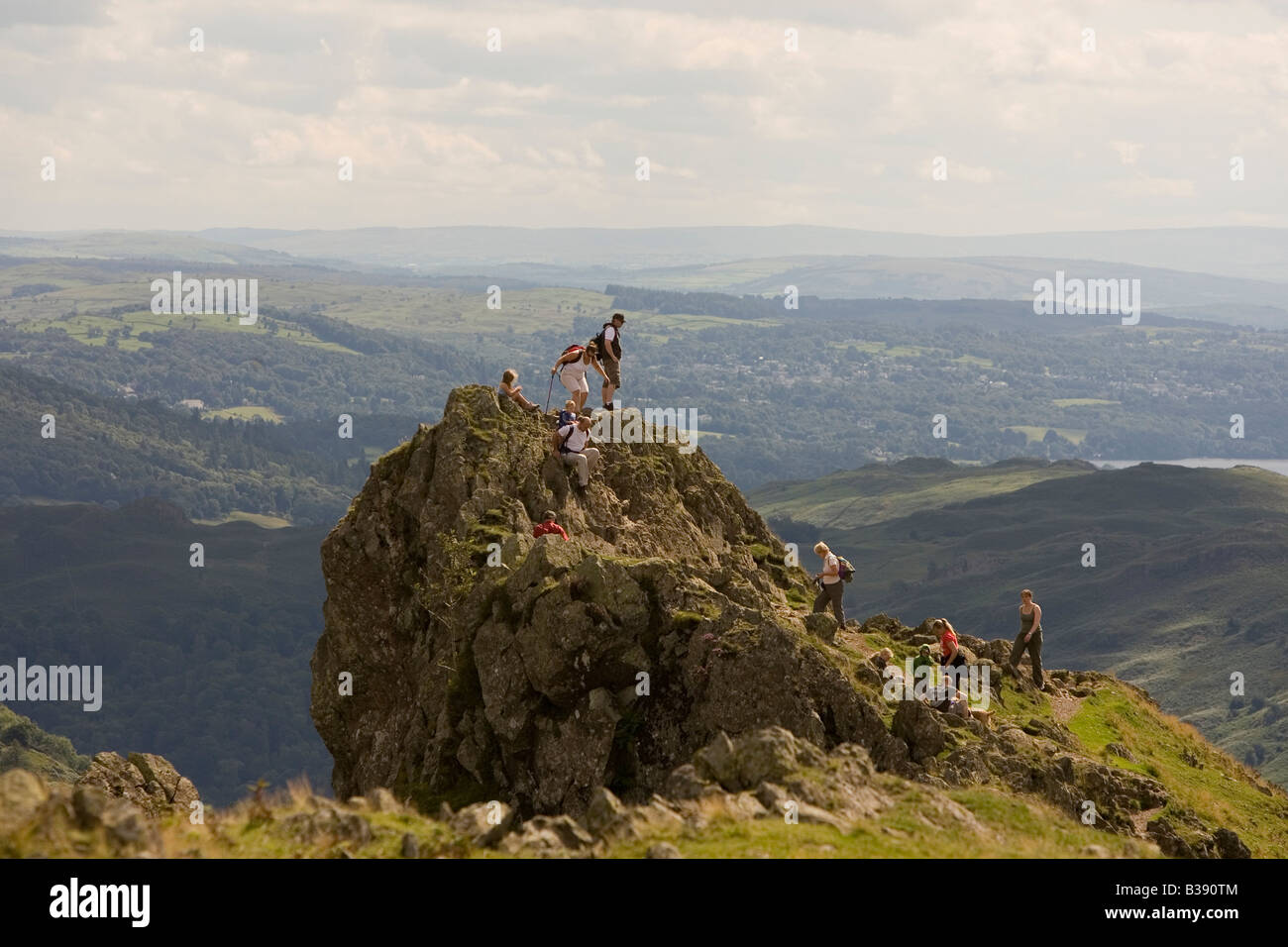 Walkers clamber on a rocky outcrop on the summit of Helm Crag ...
