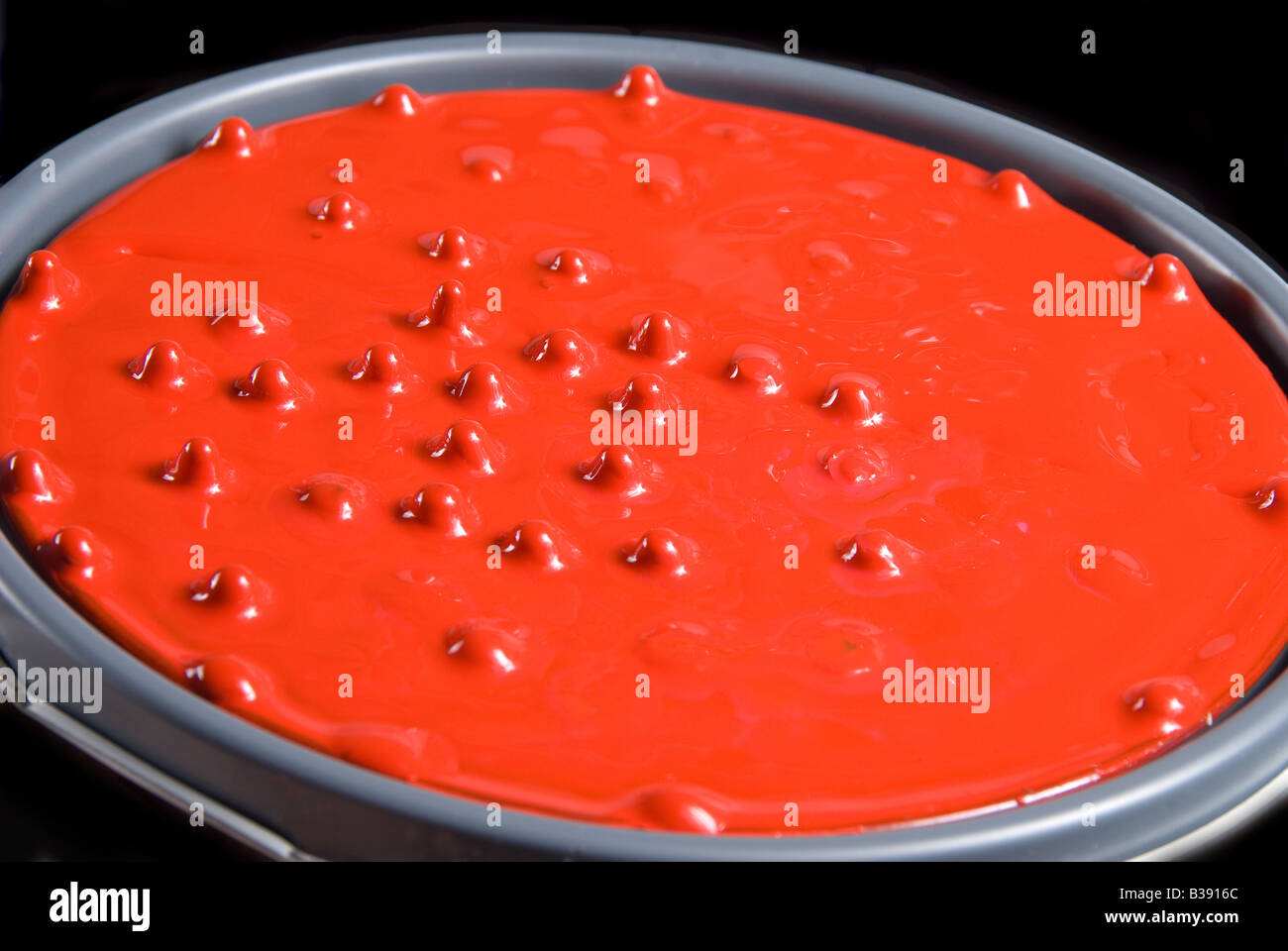 Red paint with formed dropletts showing the rich color of the pigment ...