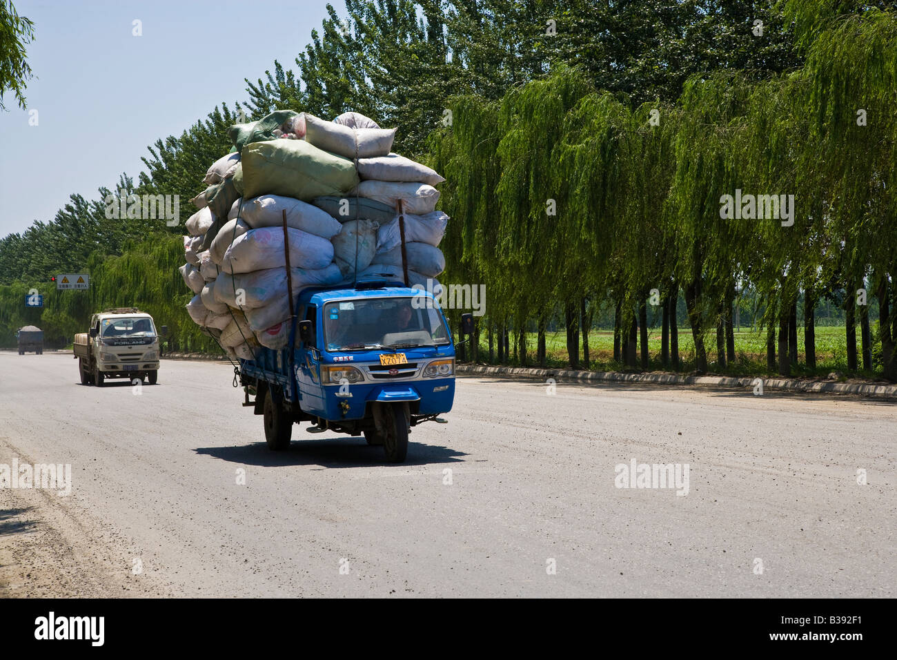 Oerverloaded blue tuk-tuk three wheeled auto rickshaw vehicle piled ...