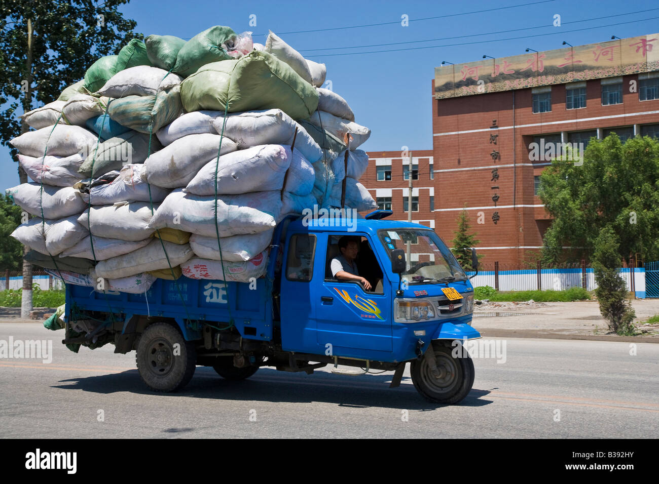 Overloaded blue tuk-tuk three wheeled auto rickshaw vehicle piled high ...