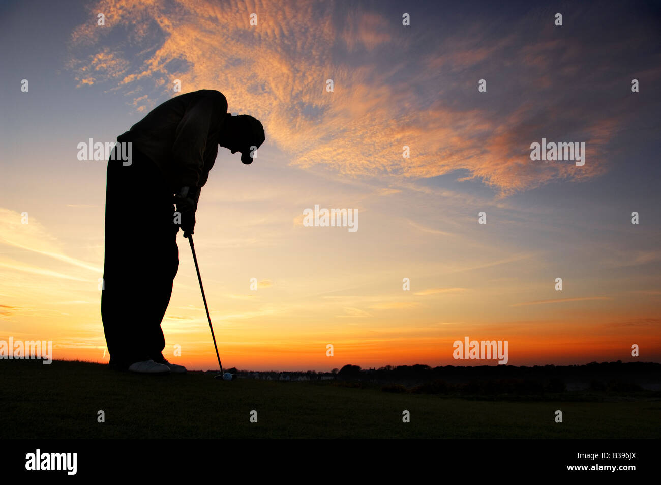 Golfer at sunset Stock Photo - Alamy
