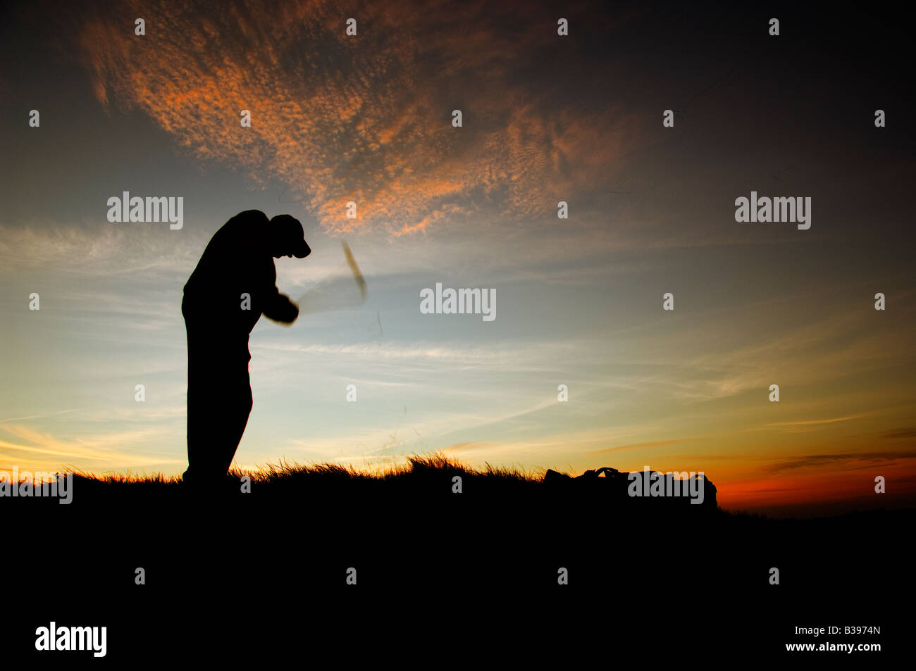 Golfer at sunset Stock Photo - Alamy