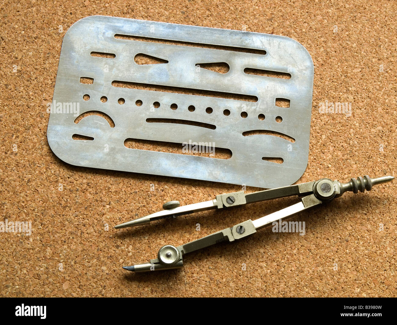 A draftsmans erasing shield and a pair of brass compasses Stock Photo ...