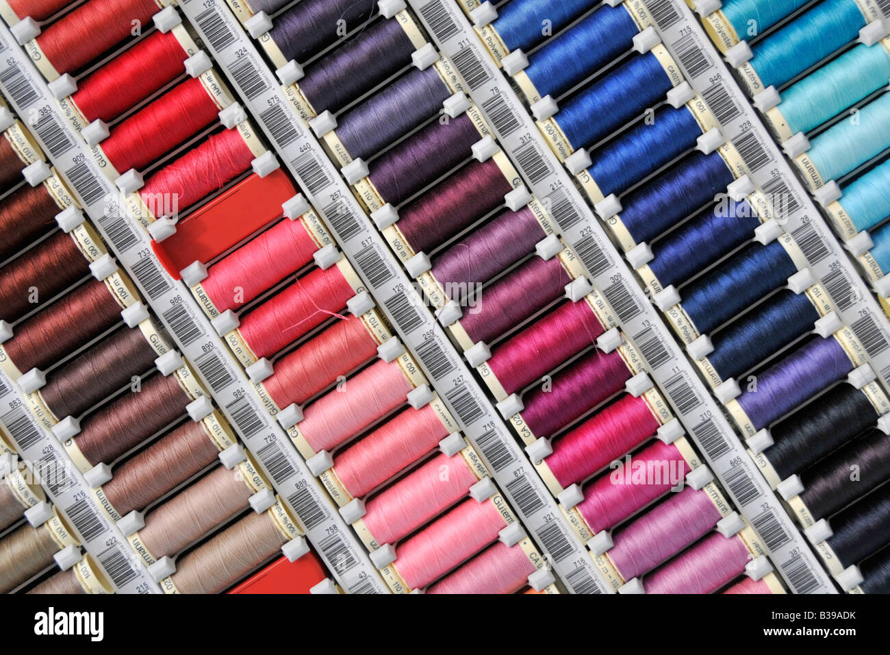 Selection of coloured threads in rack on display in shop Stock Photo ...