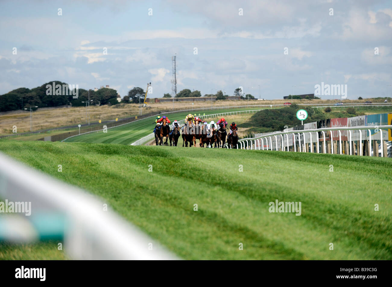 Horses race up the hill towards the finishing post at Brighton Races ...