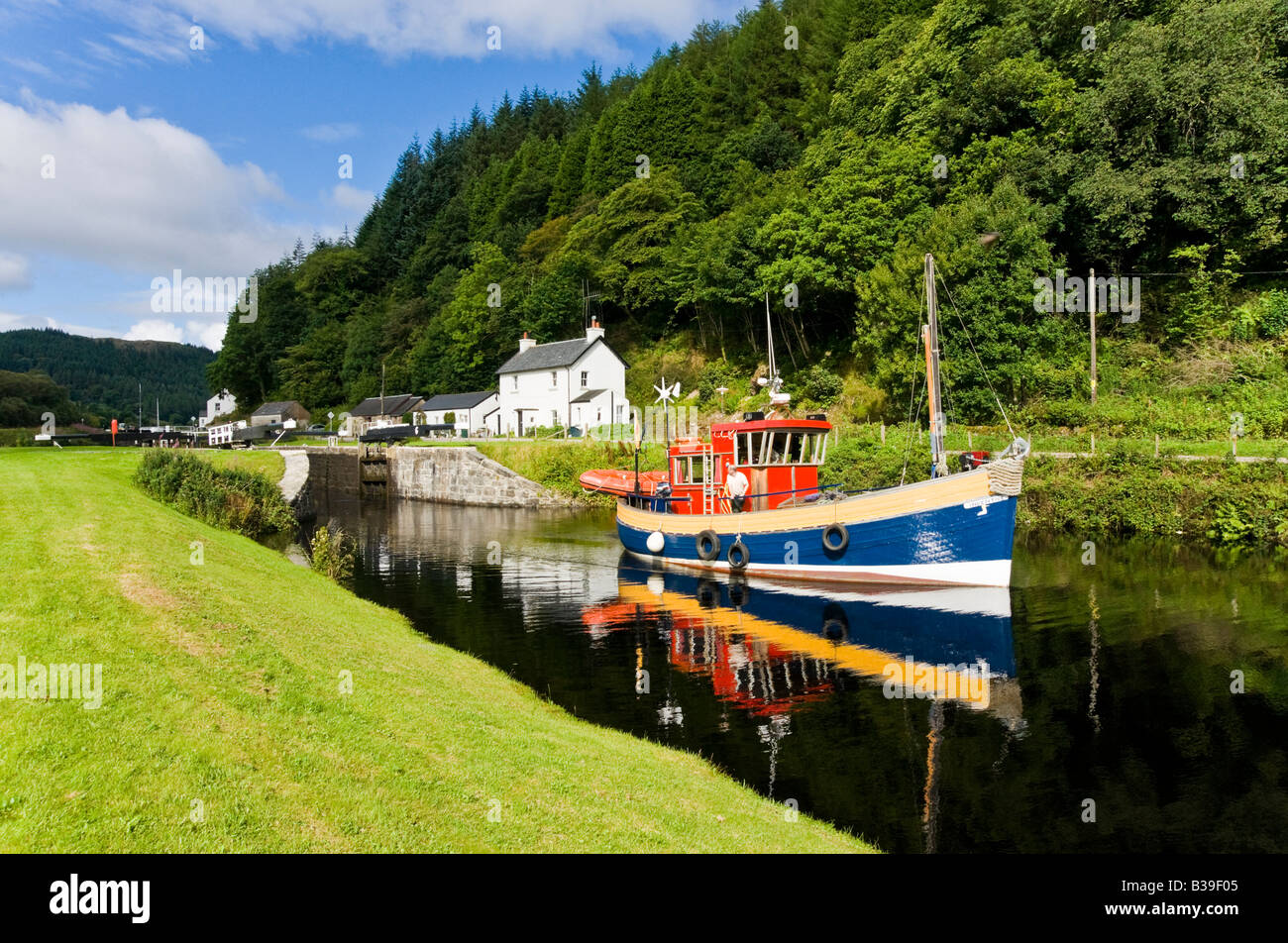 Colourful vessel leaving one of the locks on the Crinan Canal at ...