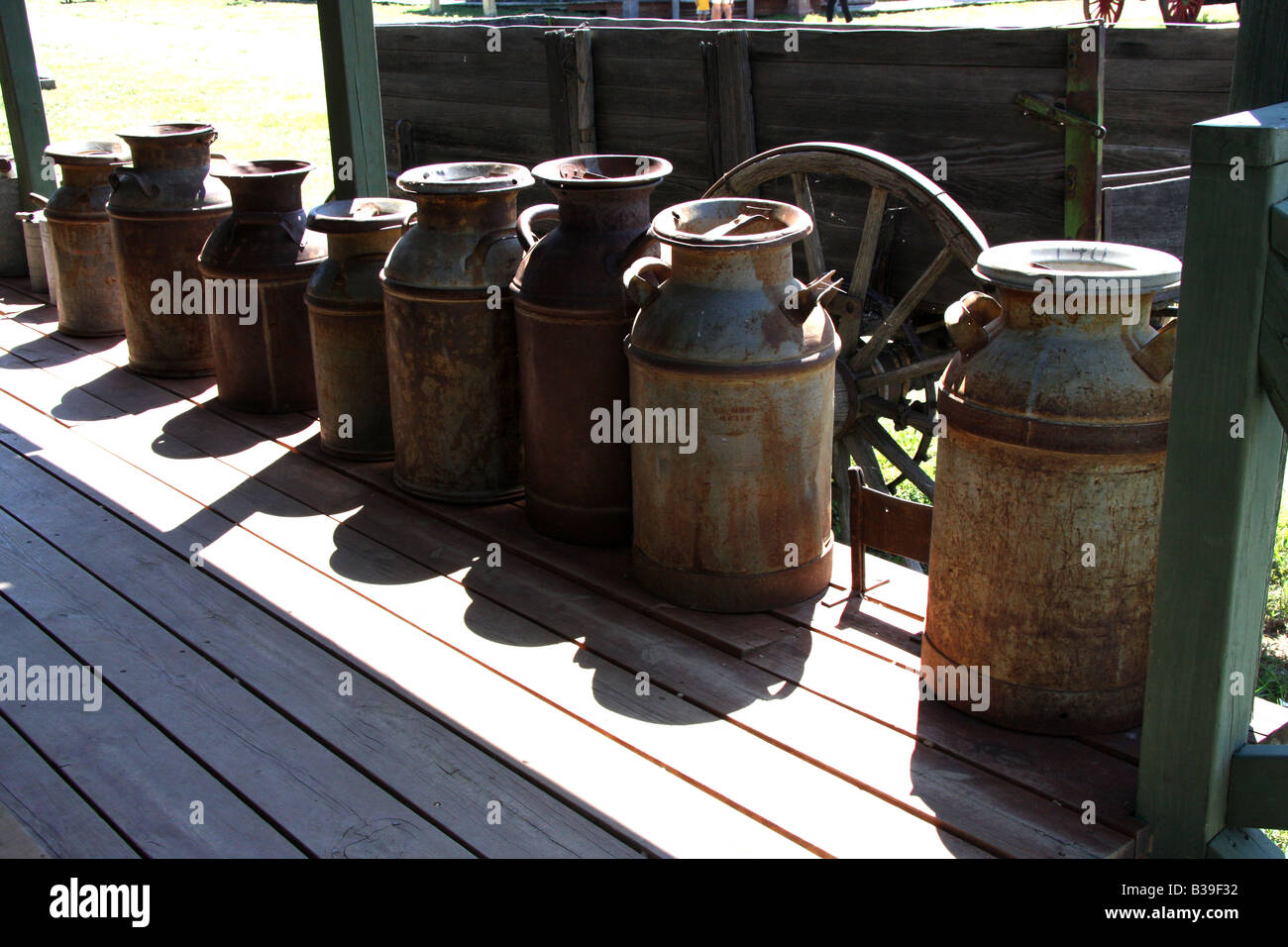 Line of cream cans with wagon in background Stock Photo - Alamy