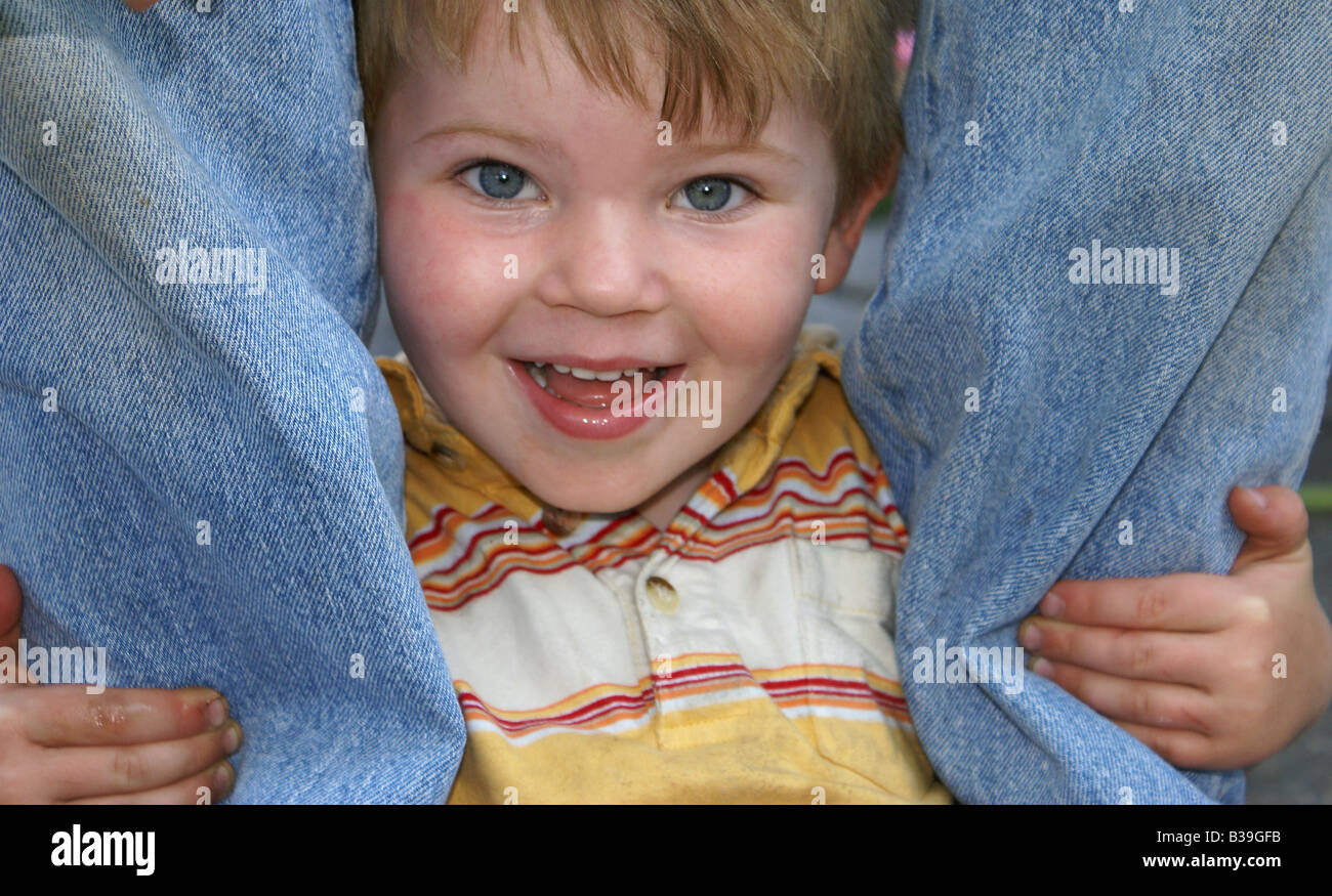 male child closeup framed between two male jean pant legs Stock Photo ...