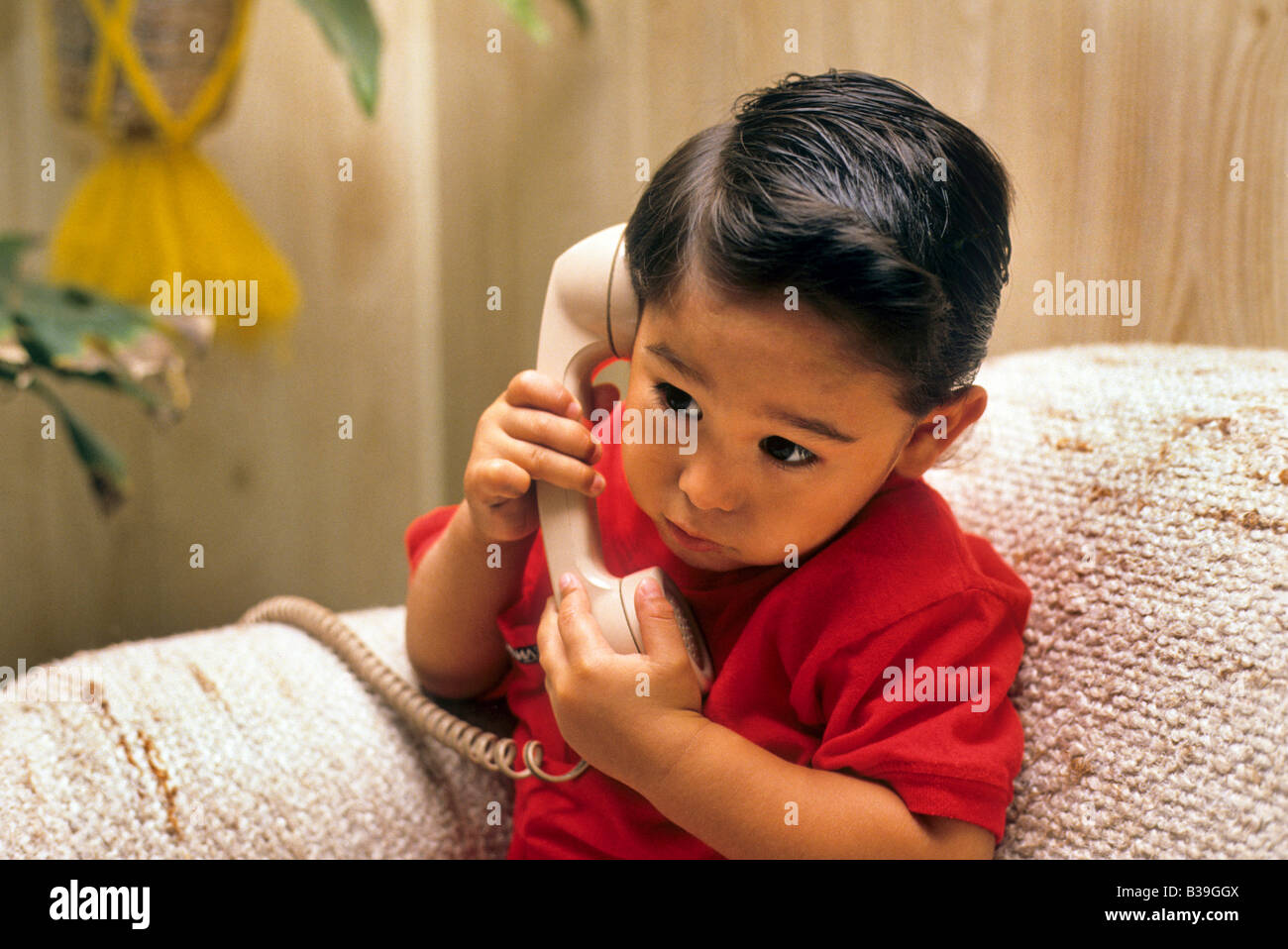 Hispanic toddler boy talks on telephone Stock Photo - Alamy