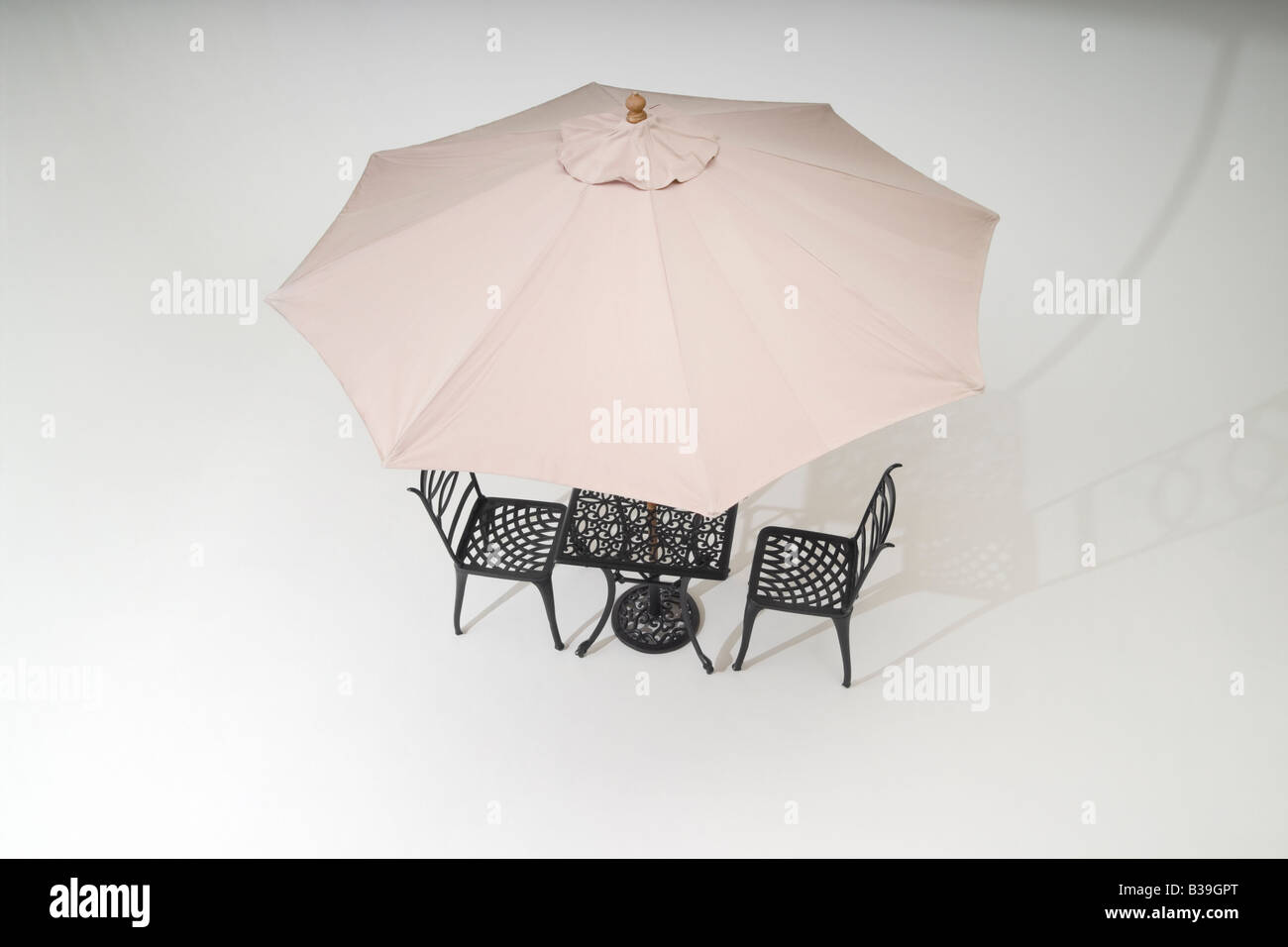Wrought iron table and chairs with parasol Stock Photo - Alamy