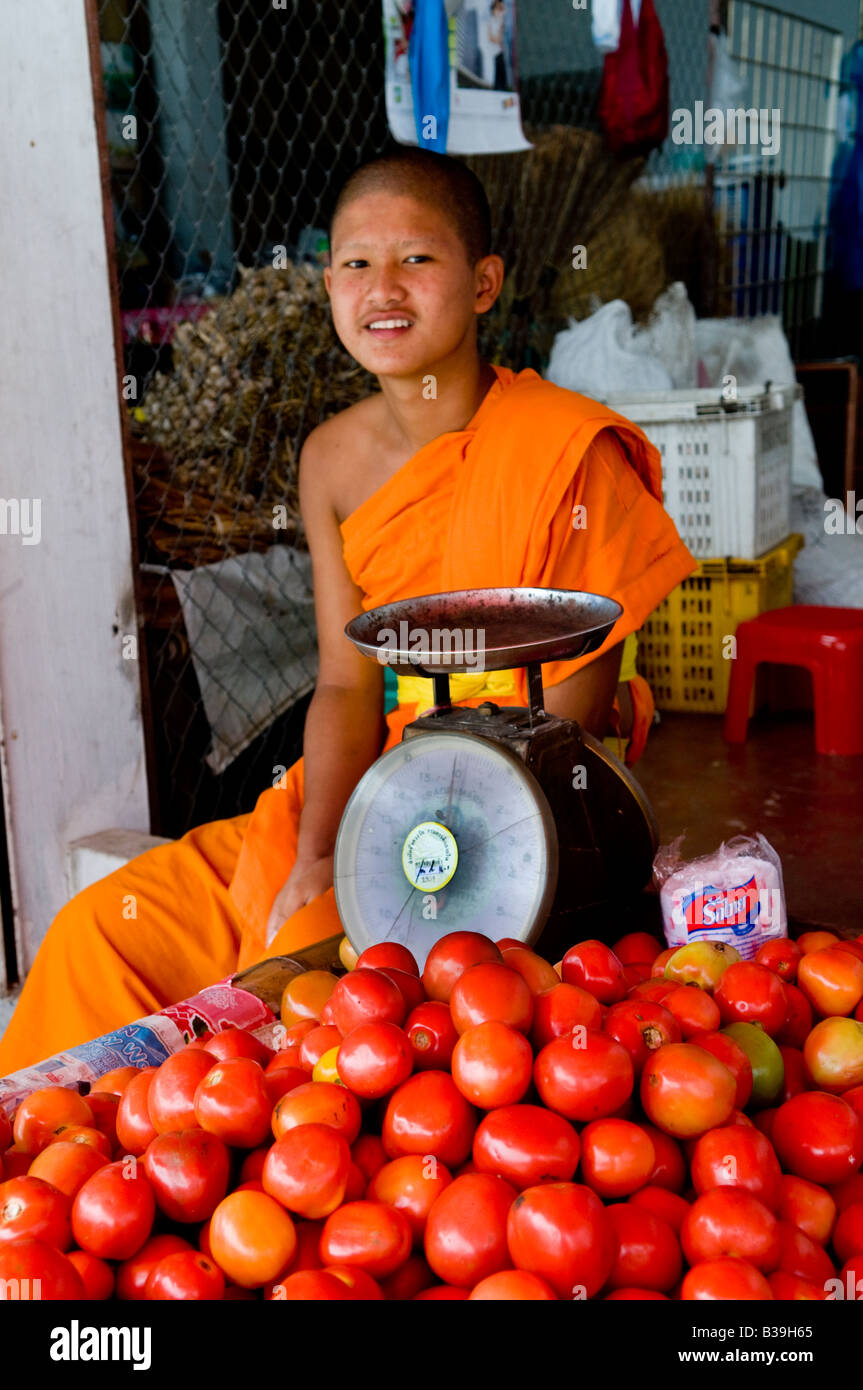 A Buddhist monk rests by the Tomatoes stall in the market of Mae Hon ...