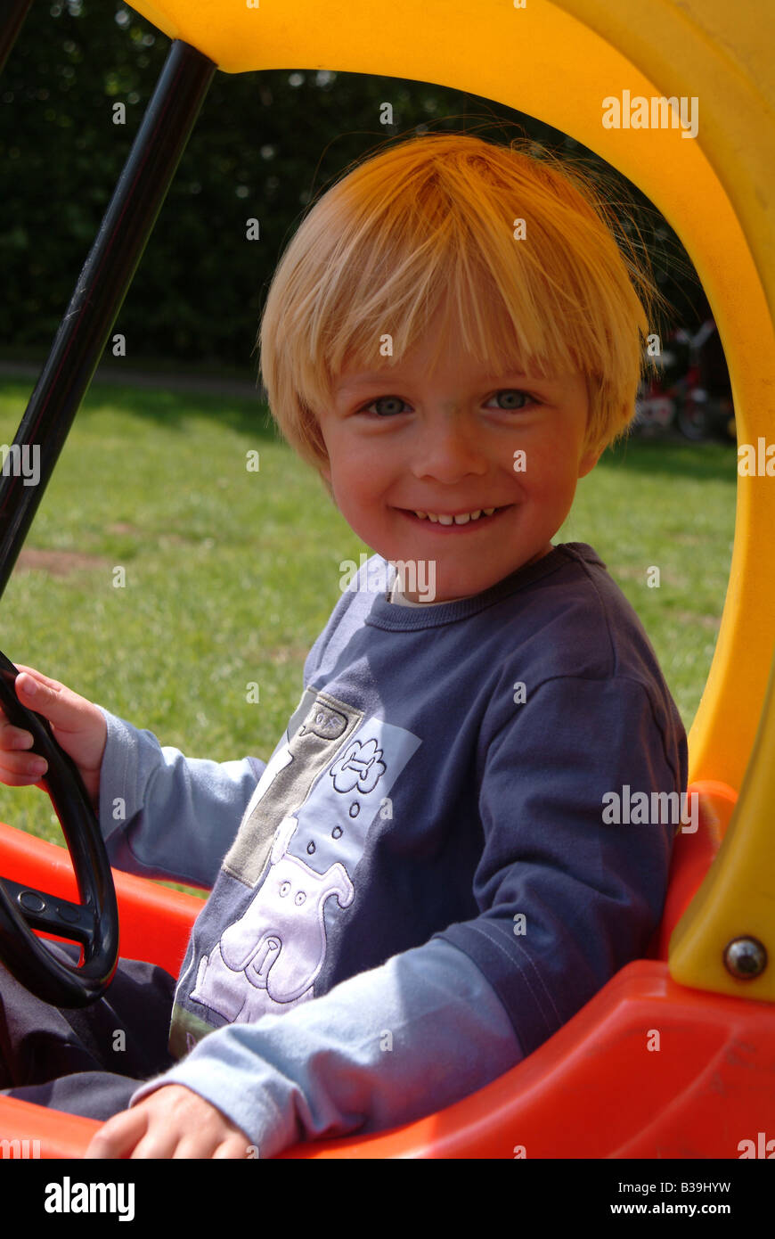 Portrait of a little boy inside a plastic car Stock Photo - Alamy