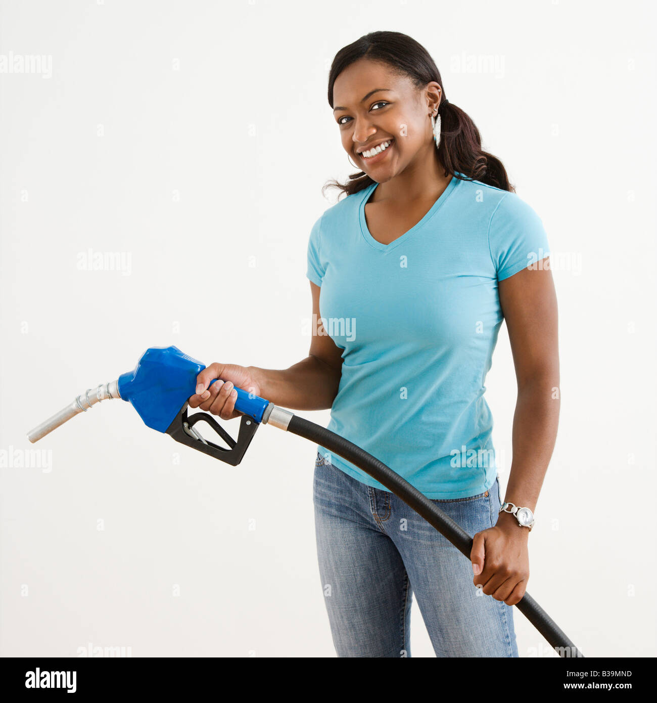 African American young adult female holding gas pump and smiling Stock ...