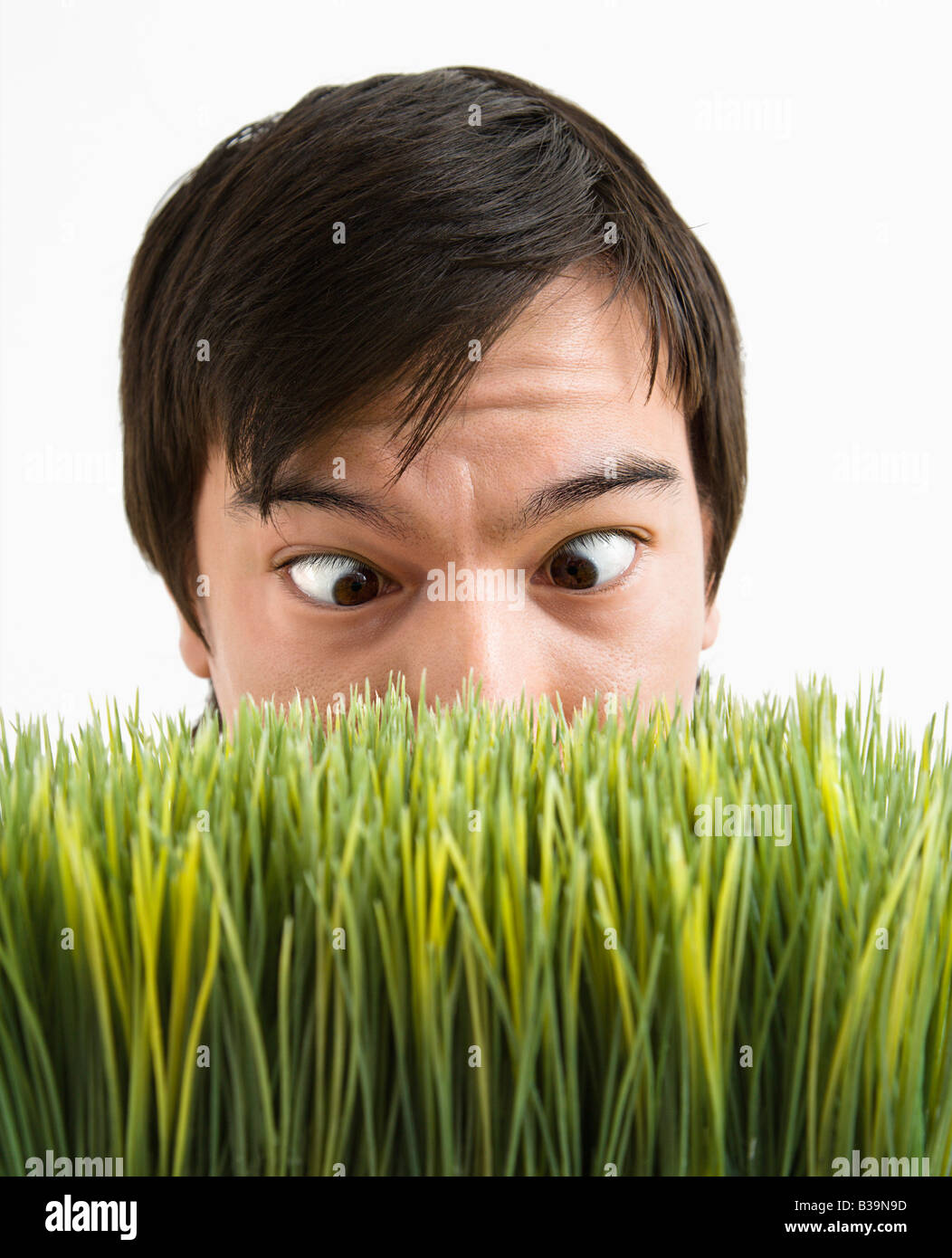 Asian young man looking over grass with eyes crossed Stock Photo - Alamy