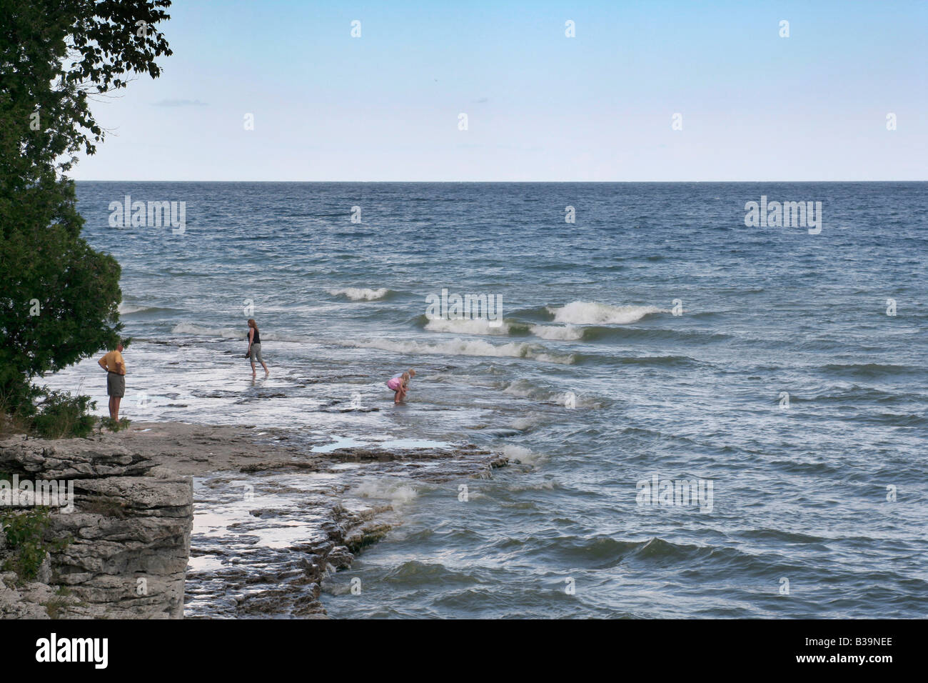Family wading along rocky shore of Lake Michigan Door County Wisconsin ...