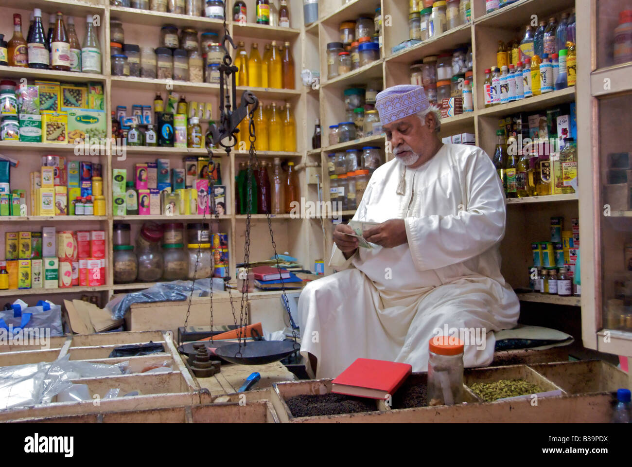 Market trader in shop counting money Old Souq Mutrah Muscat Oman Stock ...