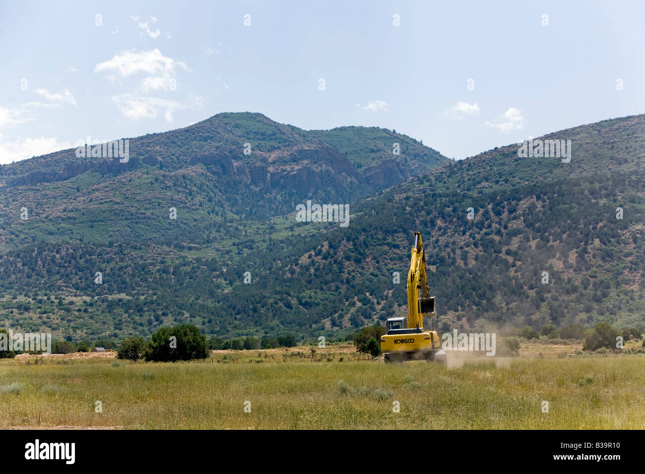Photo of a large excavator tracked backhoe working and helping to build ...
