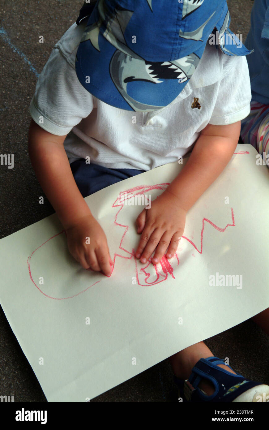 Little boy drawing with crayons on paper Stock Photo - Alamy