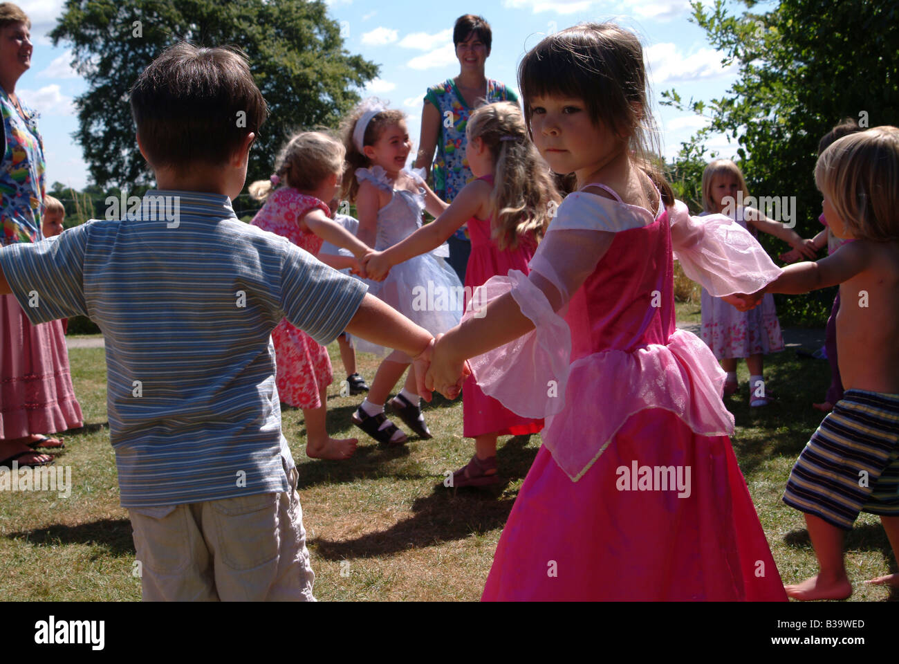 Nursery children holding hands and dancing in a circle Stock Photo - Alamy