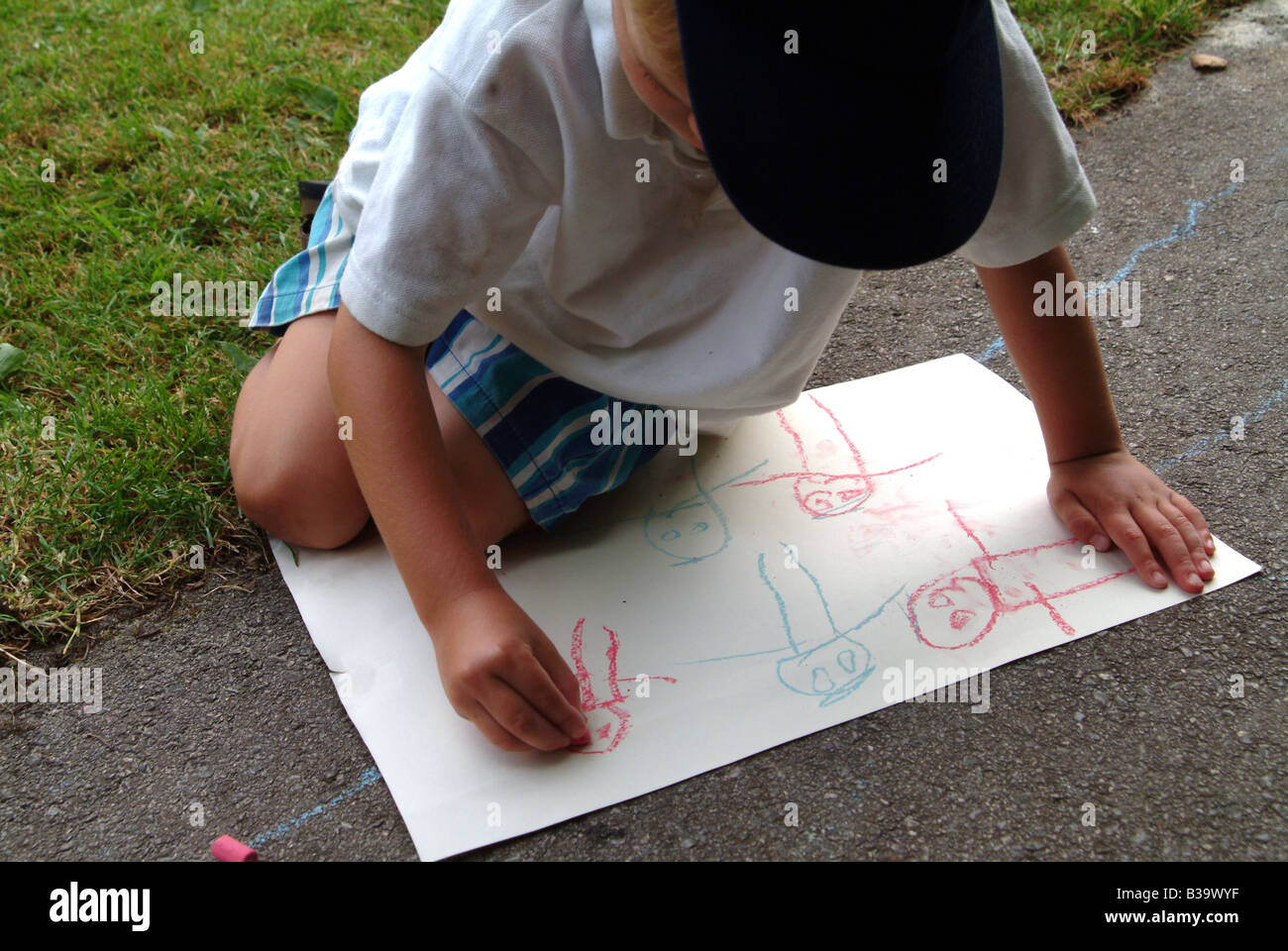Little boy drawing with crayons on paper Stock Photo - Alamy