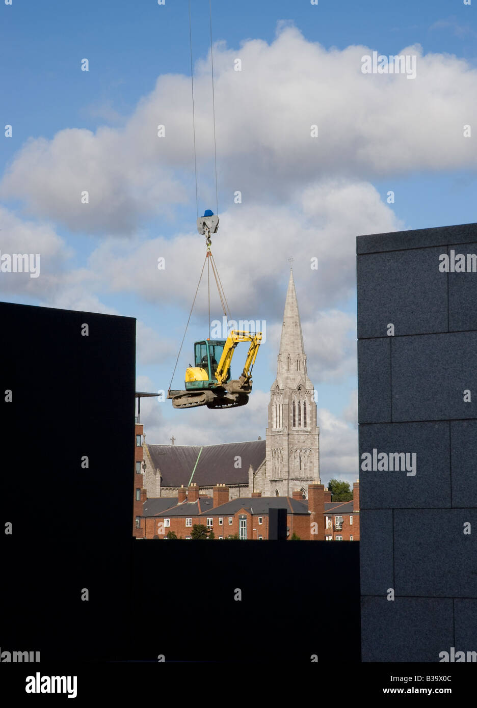 City construction building digger being hoisted over building air lift ...