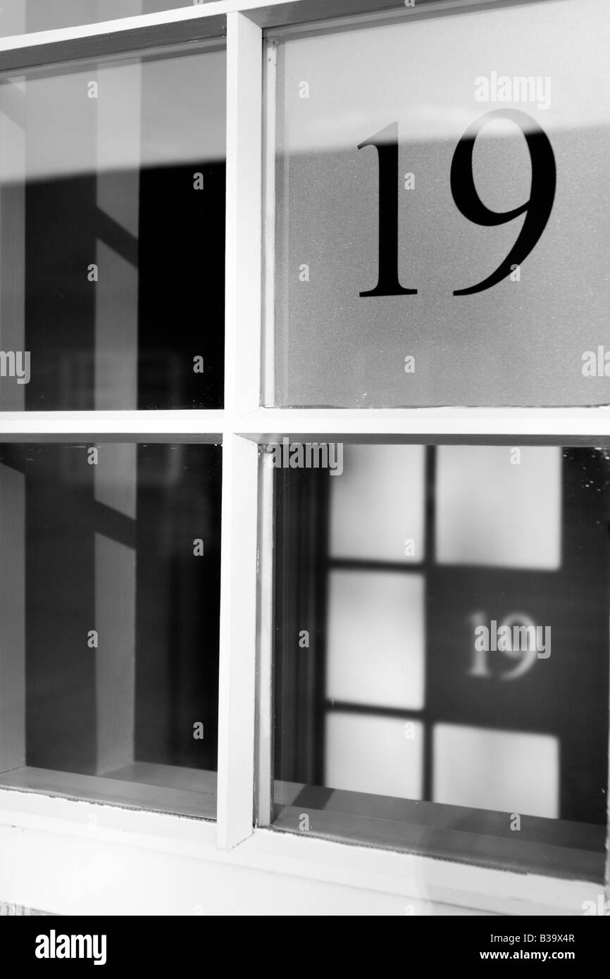 The number 19 (nineteen) etched onto window glass, with strong shadows ...