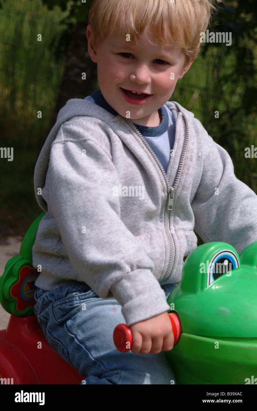 Little boy sitting on a plastic ride along toy Stock Photo - Alamy