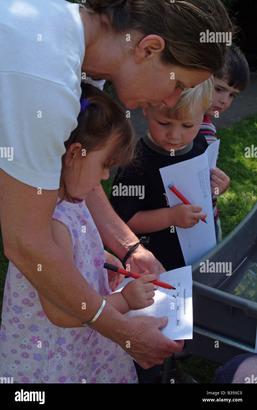 Children outside with paper and pencils Stock Photo - Alamy