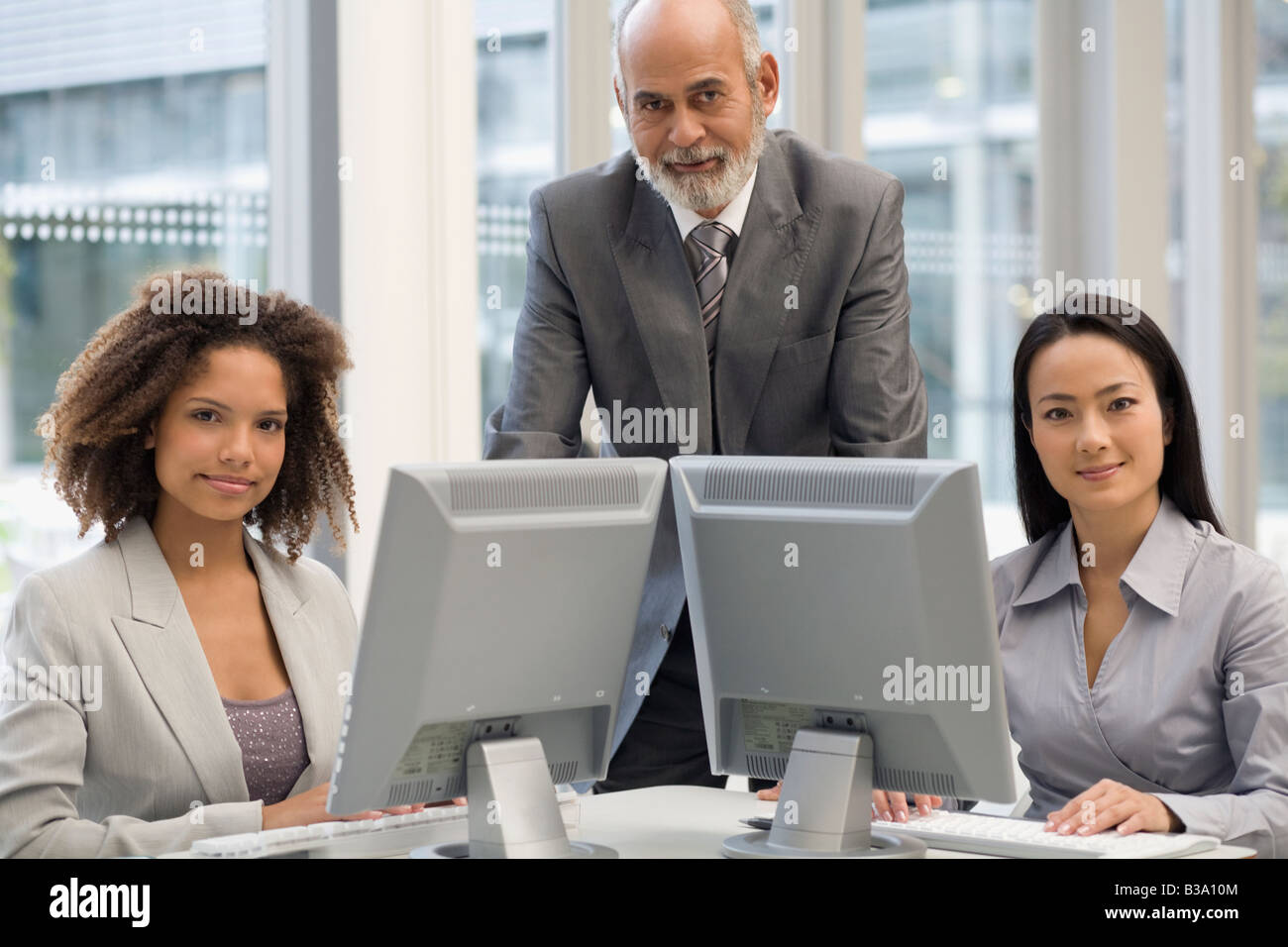 Multi-ethnic businesspeople behind computers Stock Photo - Alamy