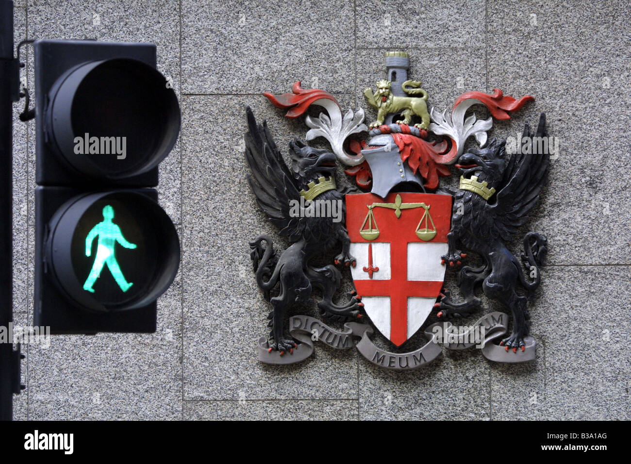 A pedestrian crossing light infront of a City of London emblem London ...
