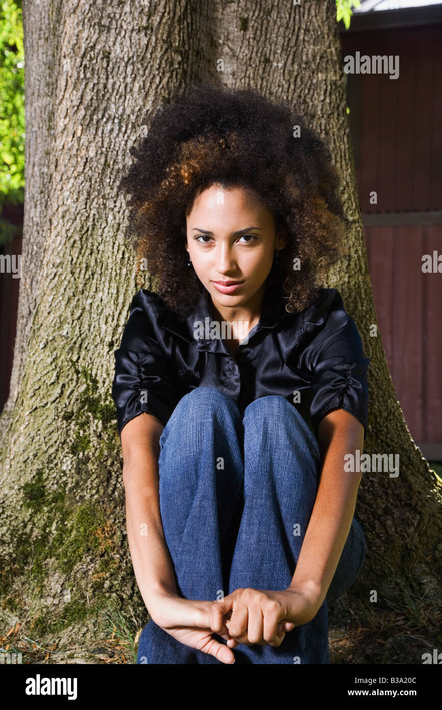 African woman sitting against tree Stock Photo - Alamy