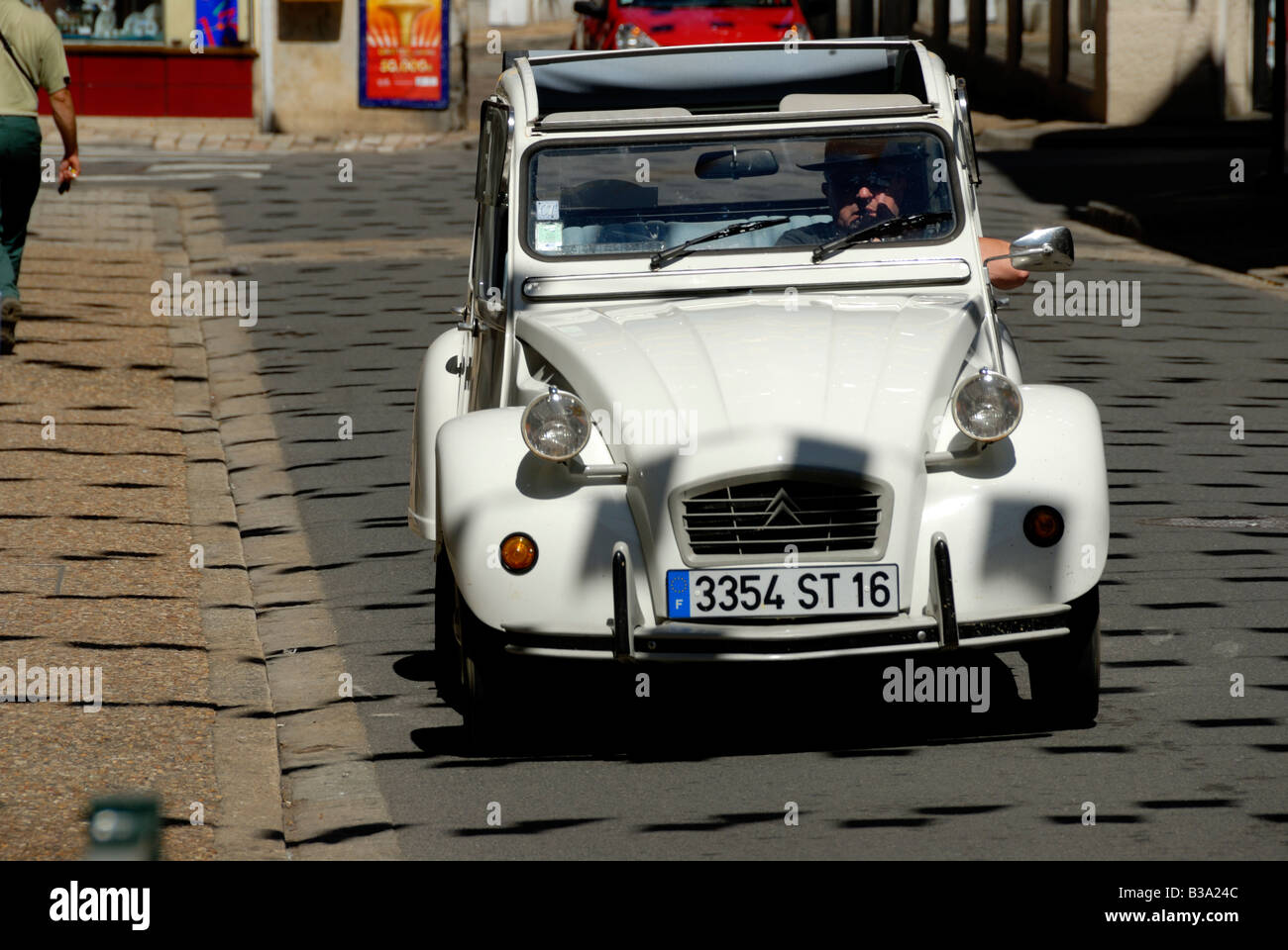 Stock photo of a white convertible Citroen 2CV car driving through the ...