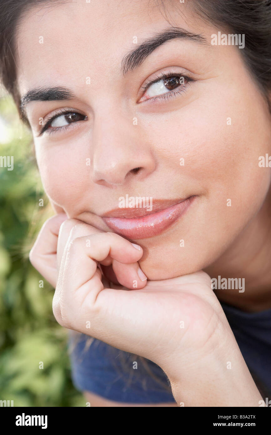 Hispanic woman resting chin on hand Stock Photo - Alamy