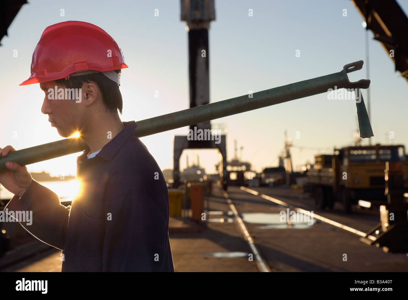 Worker carrying pipe hi-res stock photography and images - Alamy