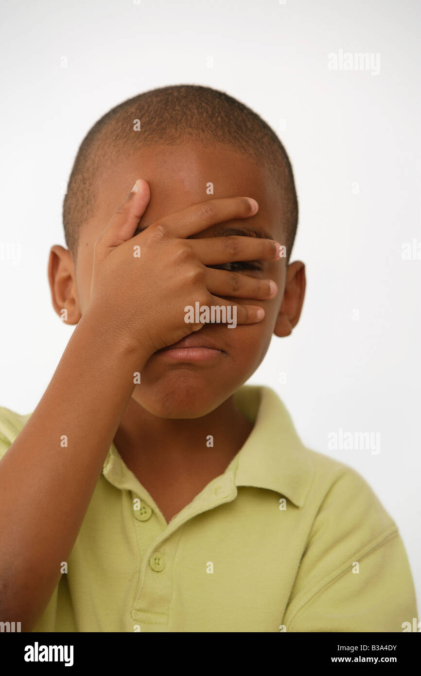 African American boy covering face with hand Stock Photo - Alamy