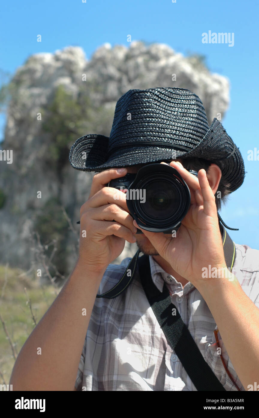 Portrait of young man using professional camera in nature background ...