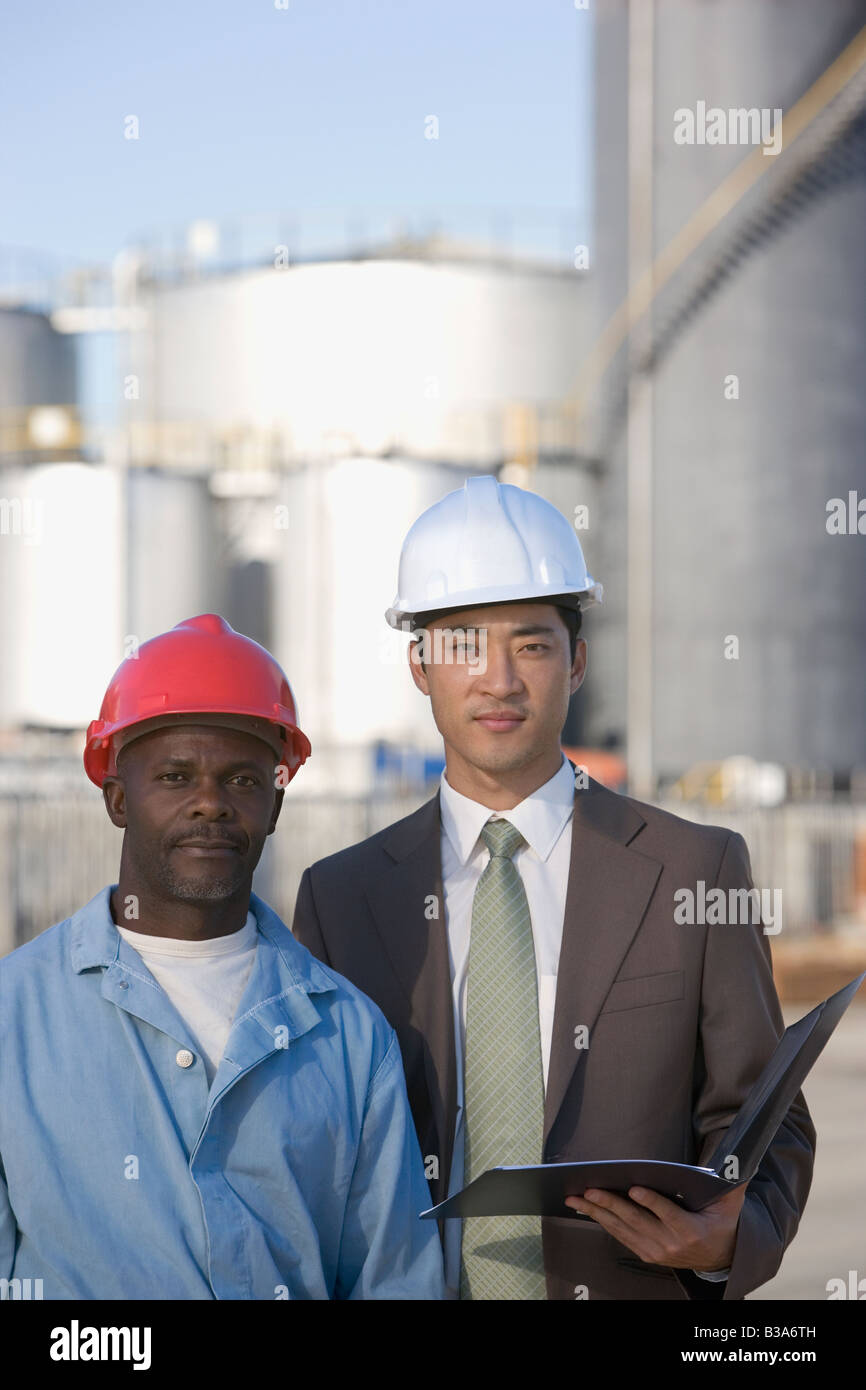 Multi-ethnic businessman and construction worker wearing hardhats Stock ...