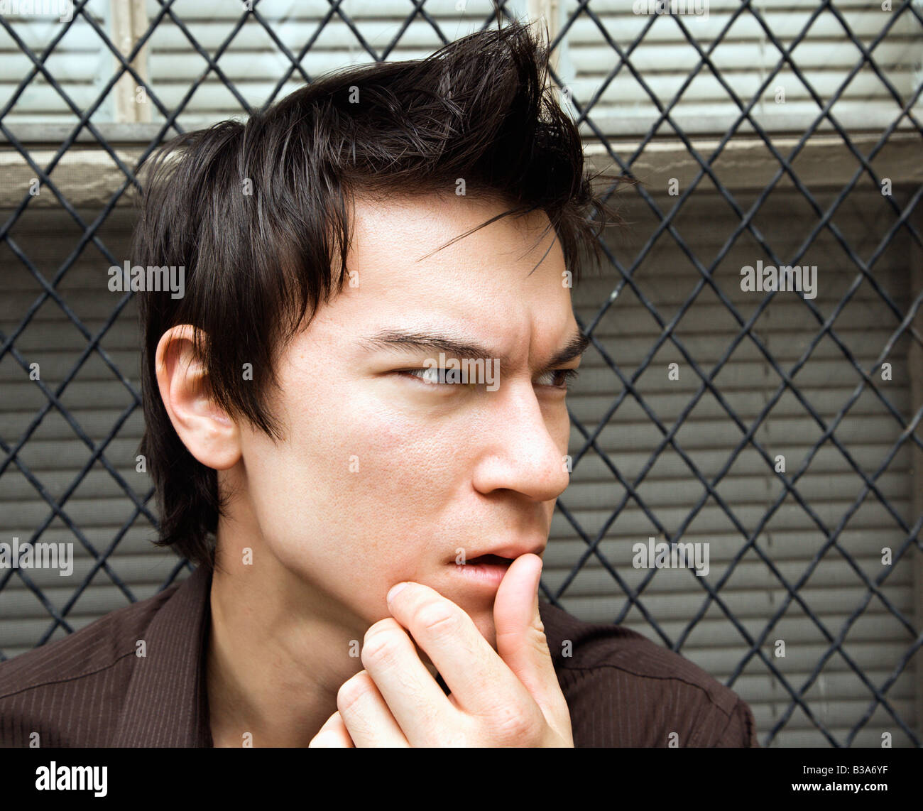 Asian man next to window looking off to side Stock Photo - Alamy