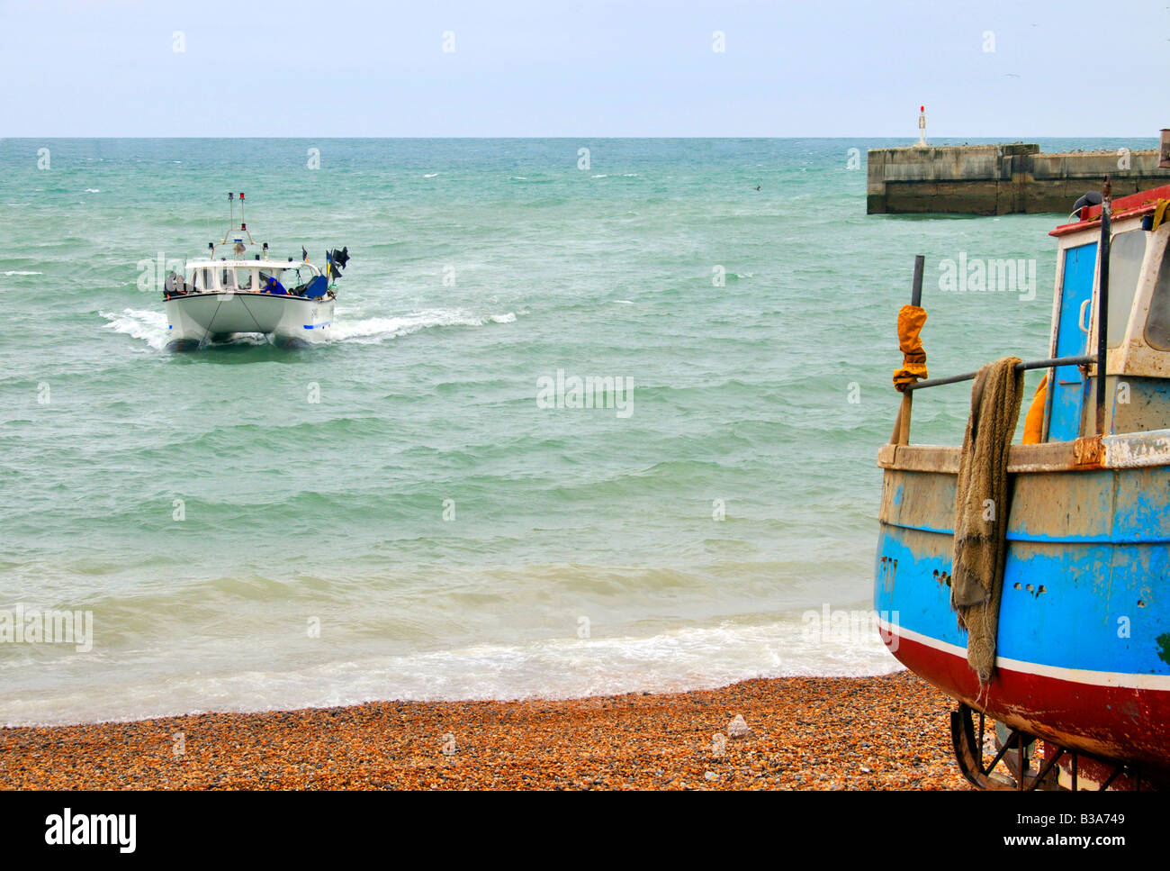 Fishing boat approaching shore Stock Photo - Alamy