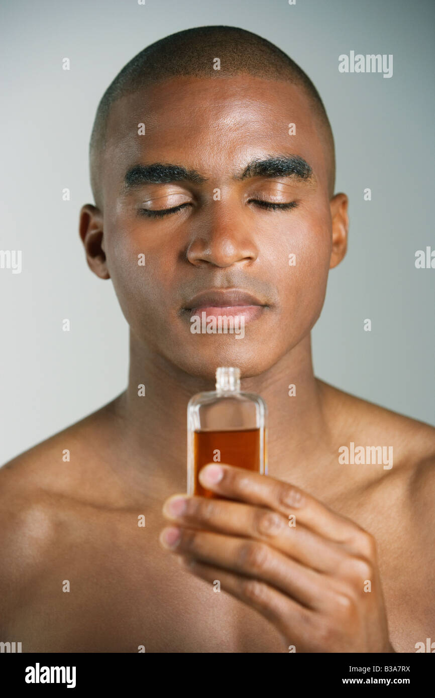 African man smelling cologne Stock Photo - Alamy