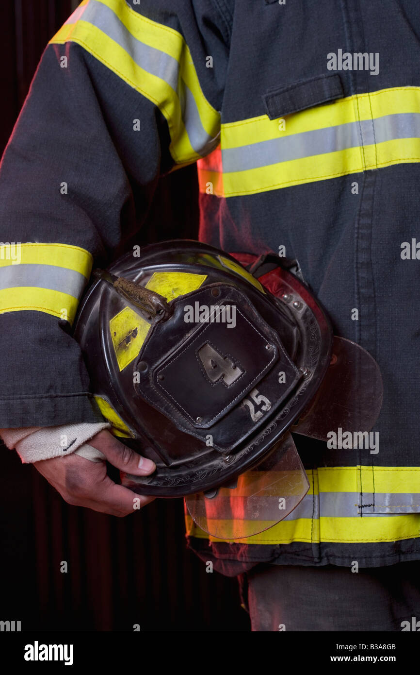 Hispanic male firefighter holding helmet Stock Photo - Alamy