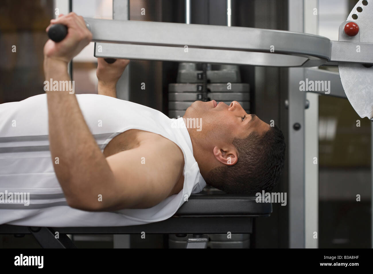 Hispanic man using exercise machine Stock Photo - Alamy